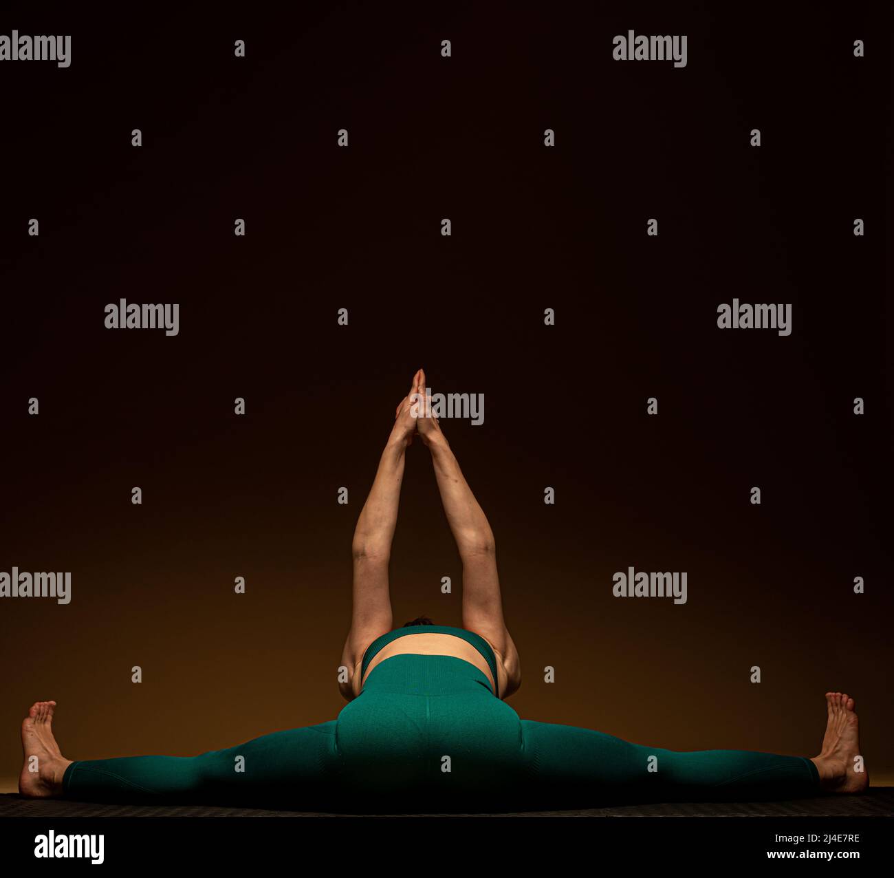 Attractive and beautiful young girl is doing splits on the ground and ...