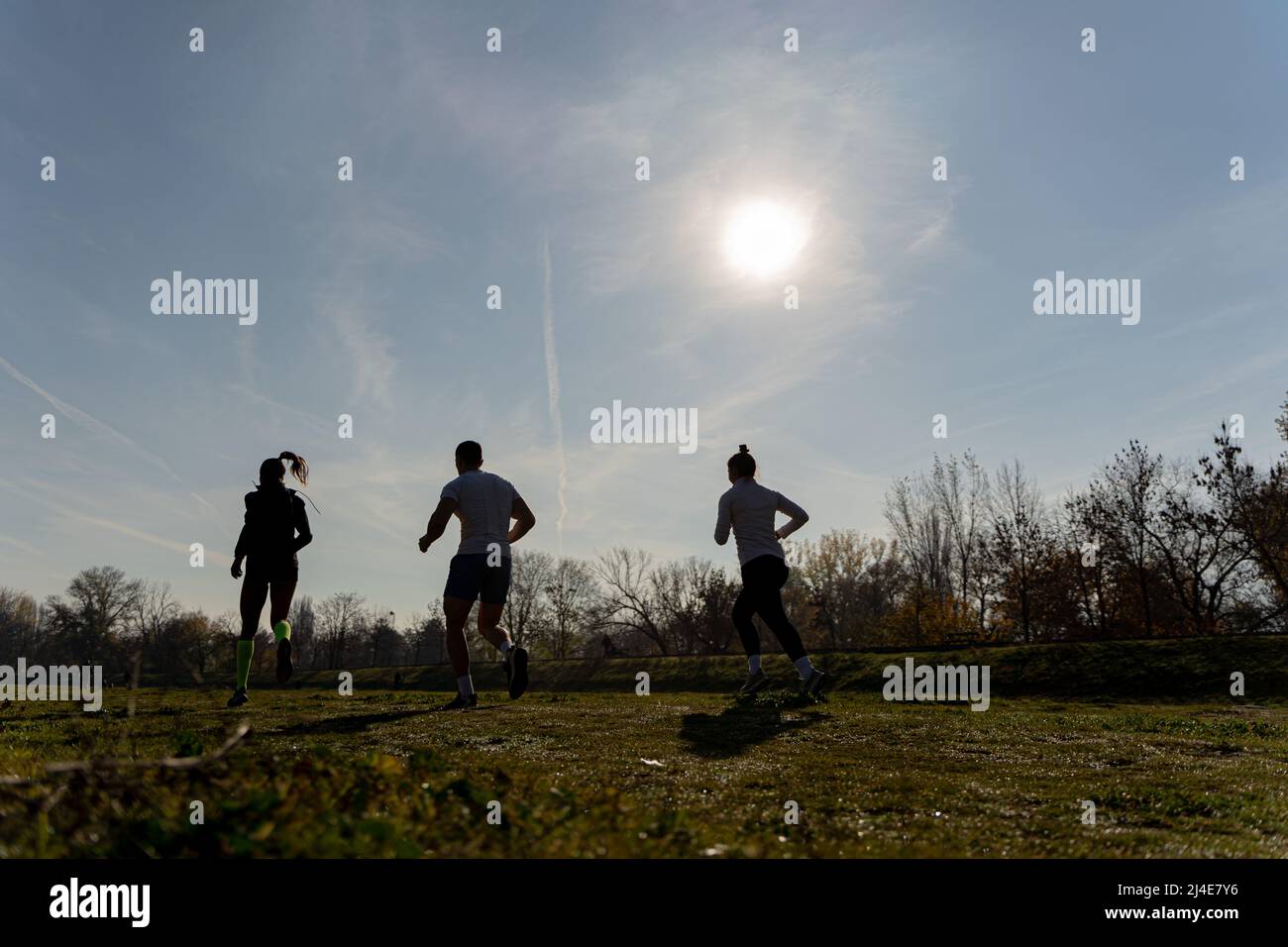 Silhouette of three amazing and fit runners, running together on the ...