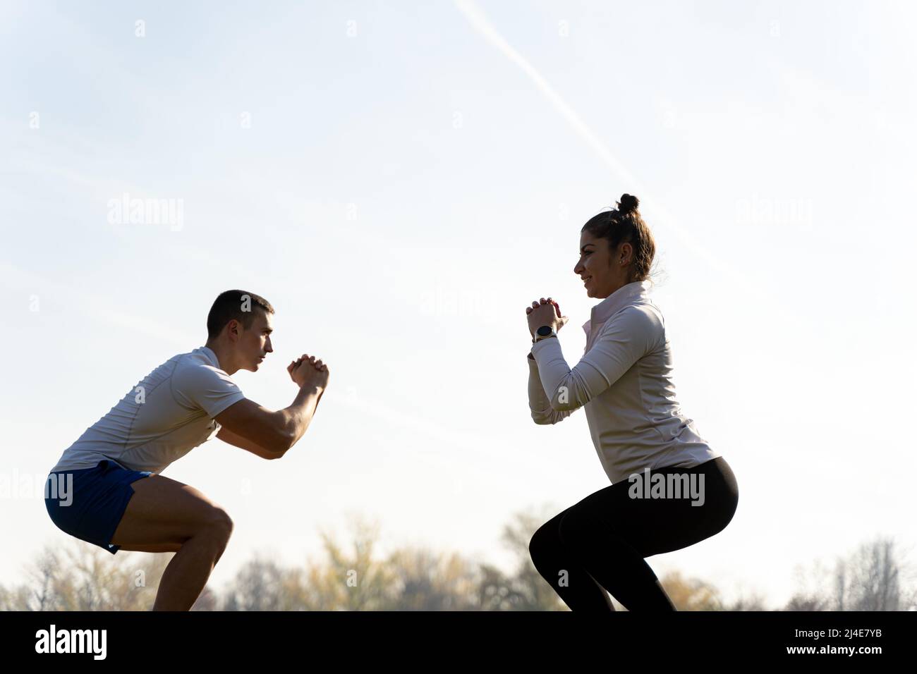 Two amazing and attractive fit friends are doing squad exercise and ...