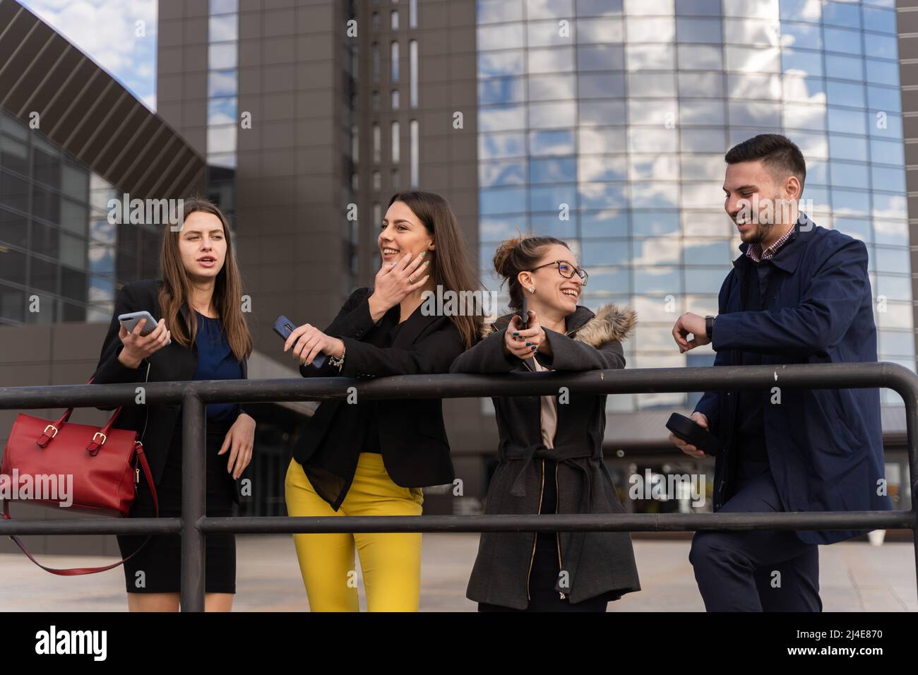 Group of young business people are laughing together outside while ...