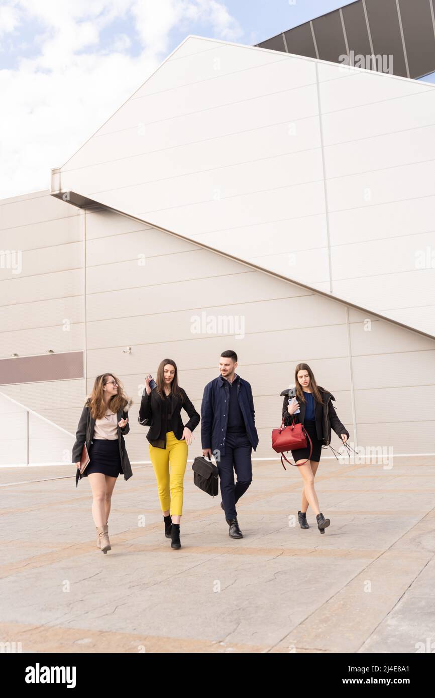 Group of young business people are walking and talking while smiling to ...