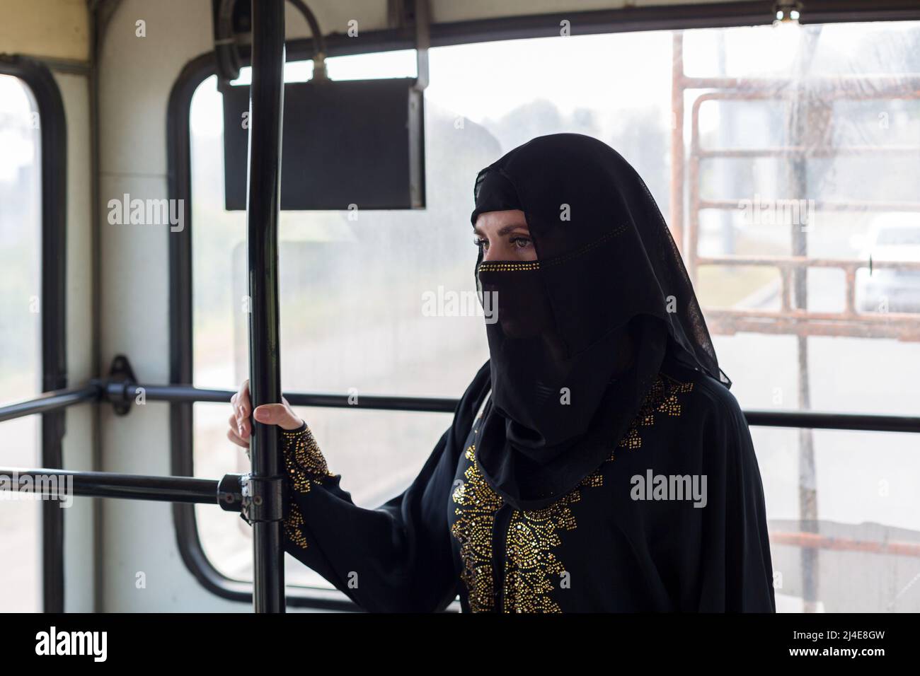 A Muslim woman in national clothes rides on public transport Stock ...