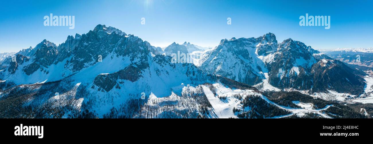 Panoramic view of snow covered mountain range against blue sky on sunny ...