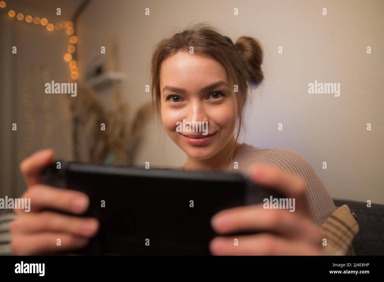 Close-up. Girl gamer plays a video game on a portable game console ...