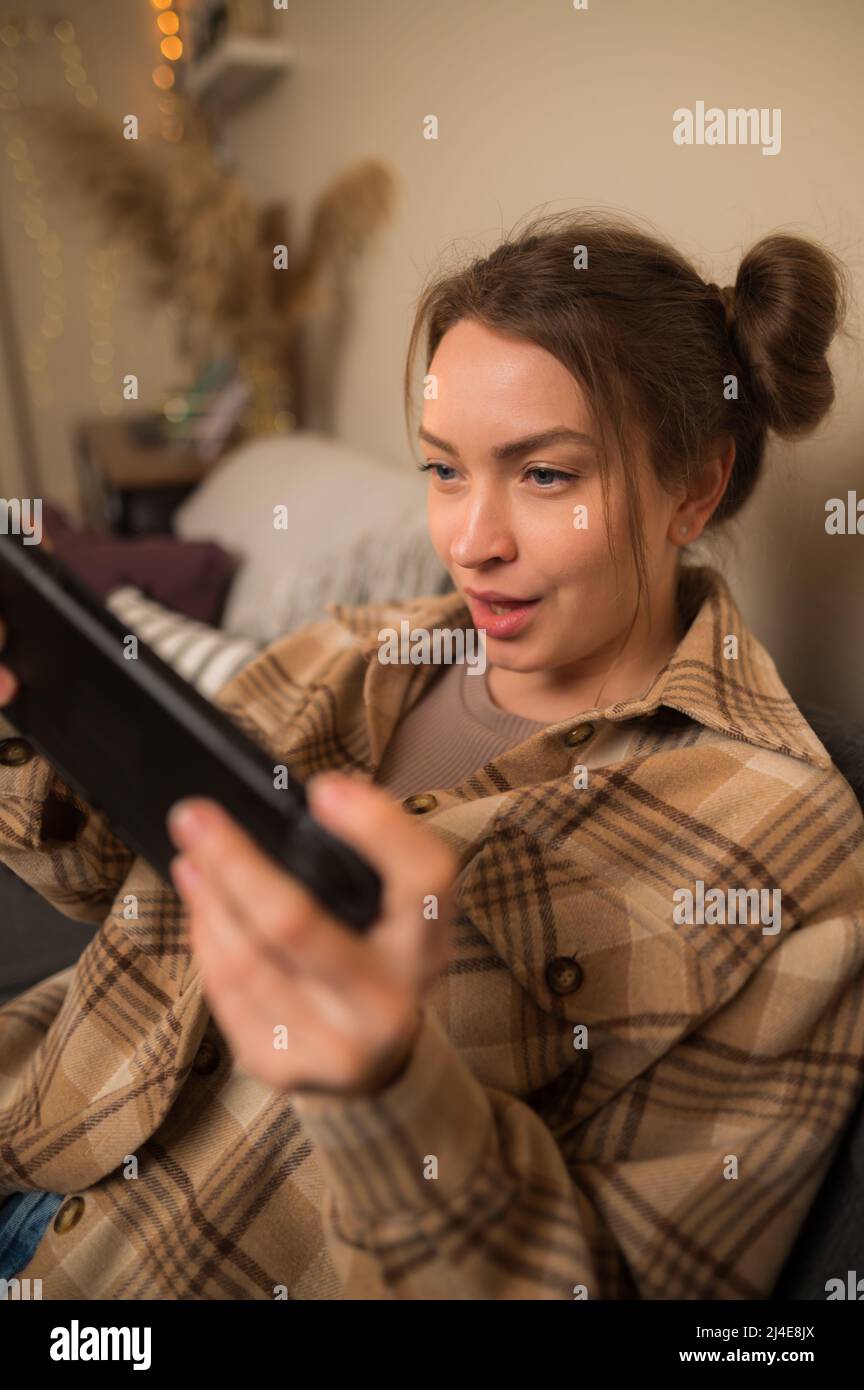 Girl gamer plays on a portable game console in a video game online with ...