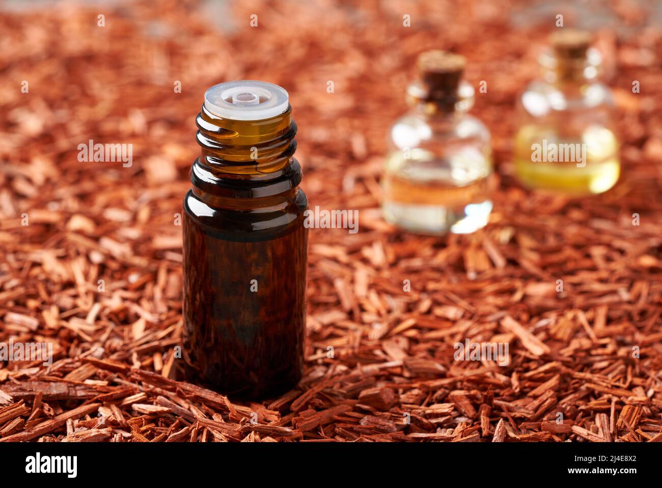 A dark bottle of essential oil with red sandalwood Stock Photo - Alamy