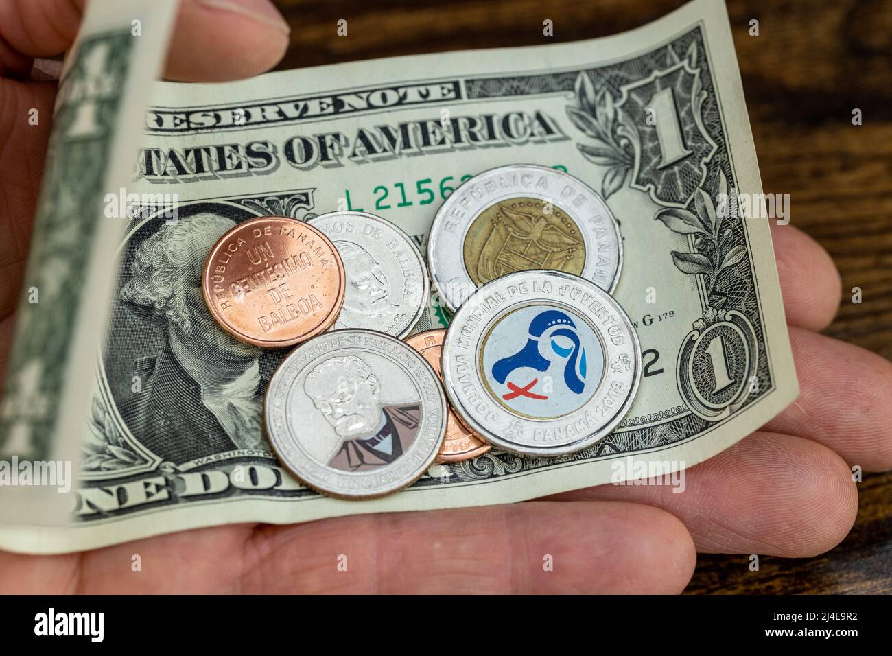 Panama money, hand held coins called Balboa and US one dollar banknote ...