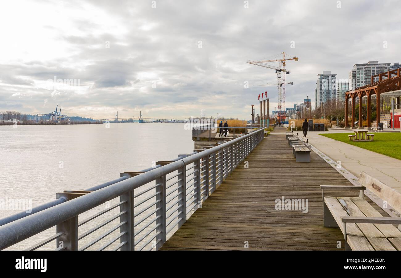 Pier and walkway by riverside in overcast day. Beautiful river park in ...