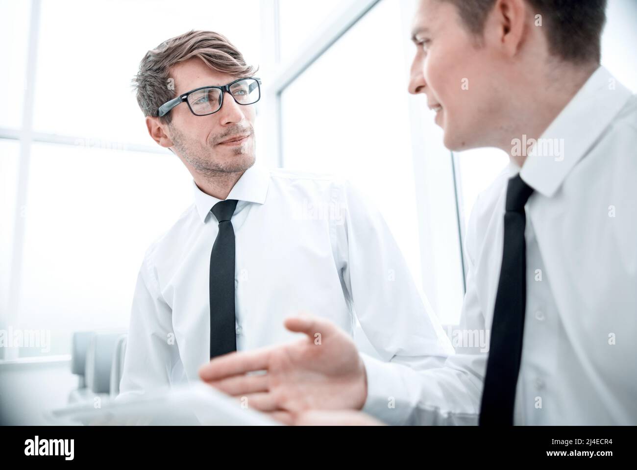 close up.two smiling employees at the Desk Stock Photo - Alamy