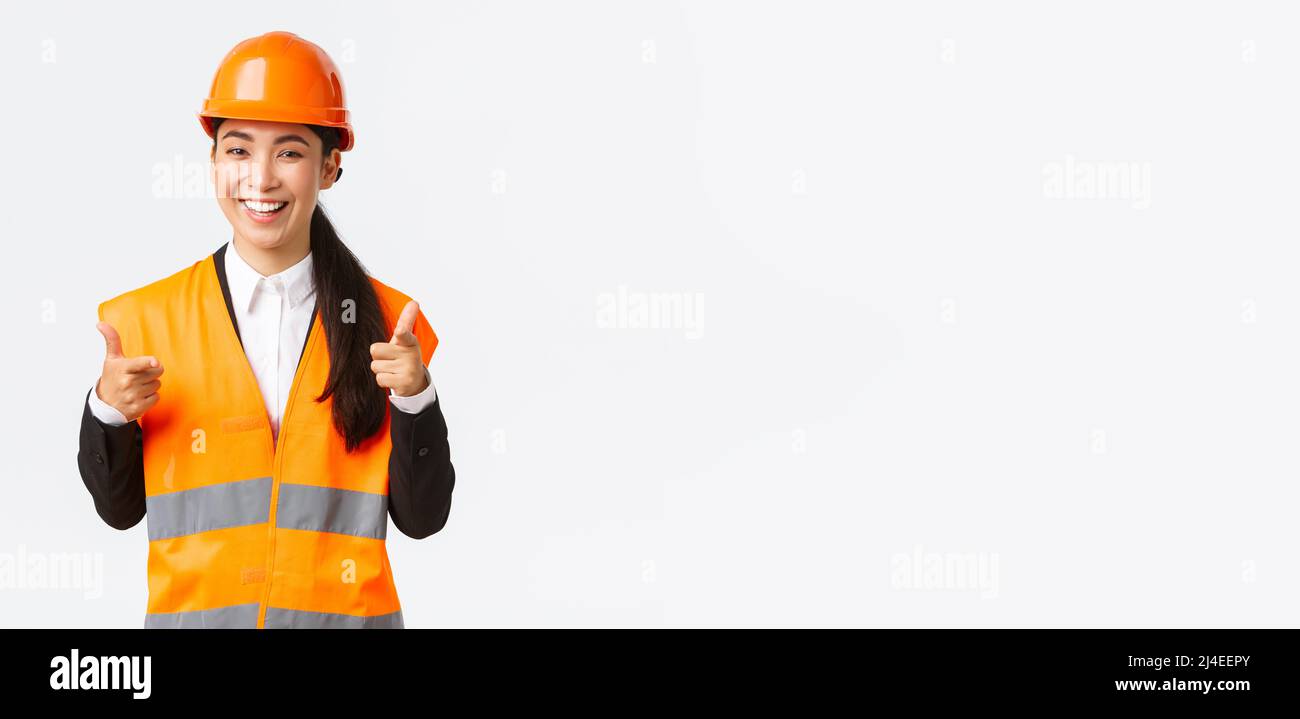 Confident pretty asian female construction manager in safety helmet and ...