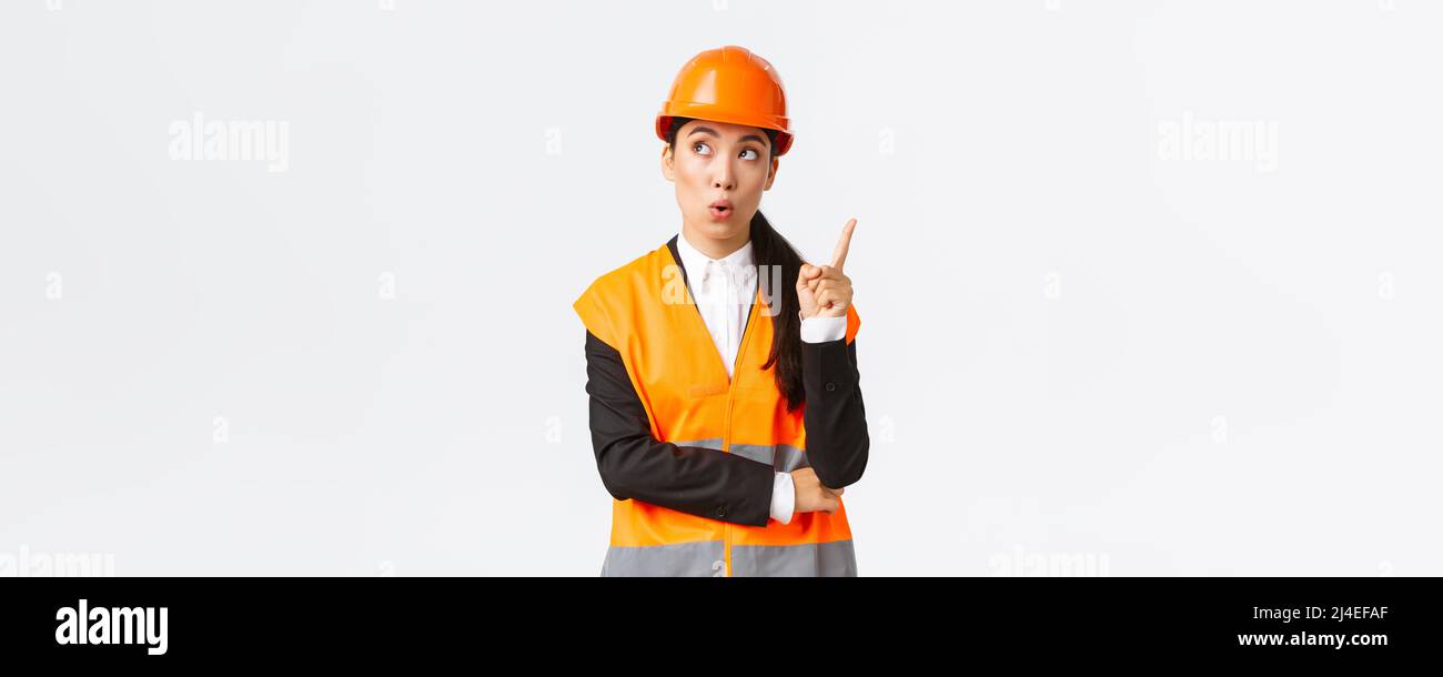 Thoughtful creative female asian engineer, architect in safety helmet ...
