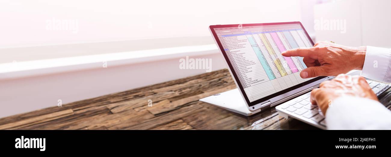 Businessman Working With Spreadsheet On Laptop In Office Stock Photo ...