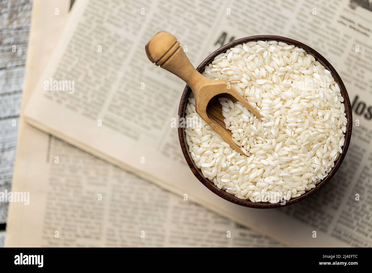 Uncooked Carnaroli risotto rice in bowl and wooden scoop on kitchen ...