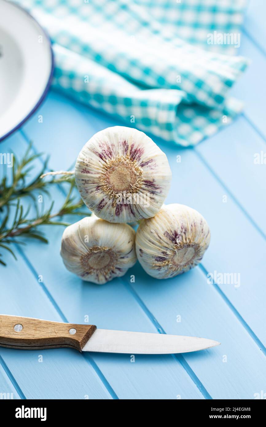Whole garlic bulb. Fresh white garlic on a blue table Stock Photo - Alamy