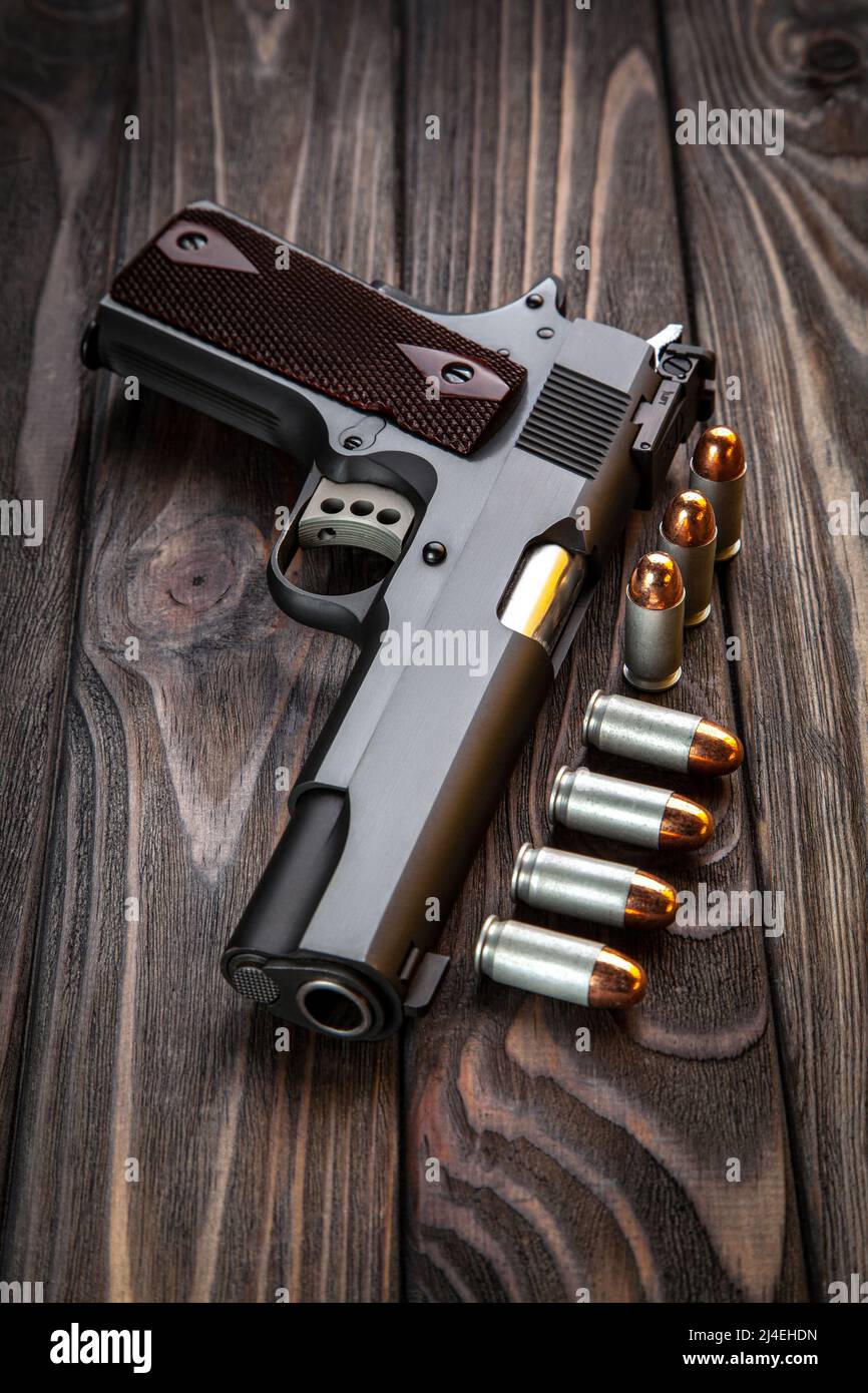 Modern black gun and ammunition on a wooden background. Pistol. Weapons ...