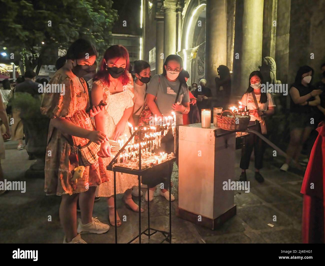 Manila, Philippines. 14th Apr, 2022. Female devotees light candles and ...