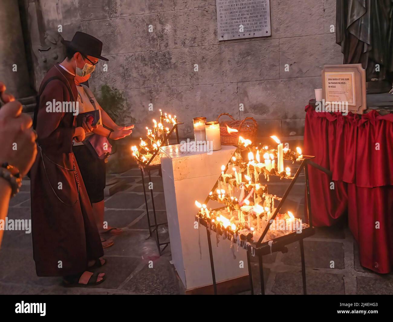 A man wearing a Spanish-era friar outfit offers his prayers during ...