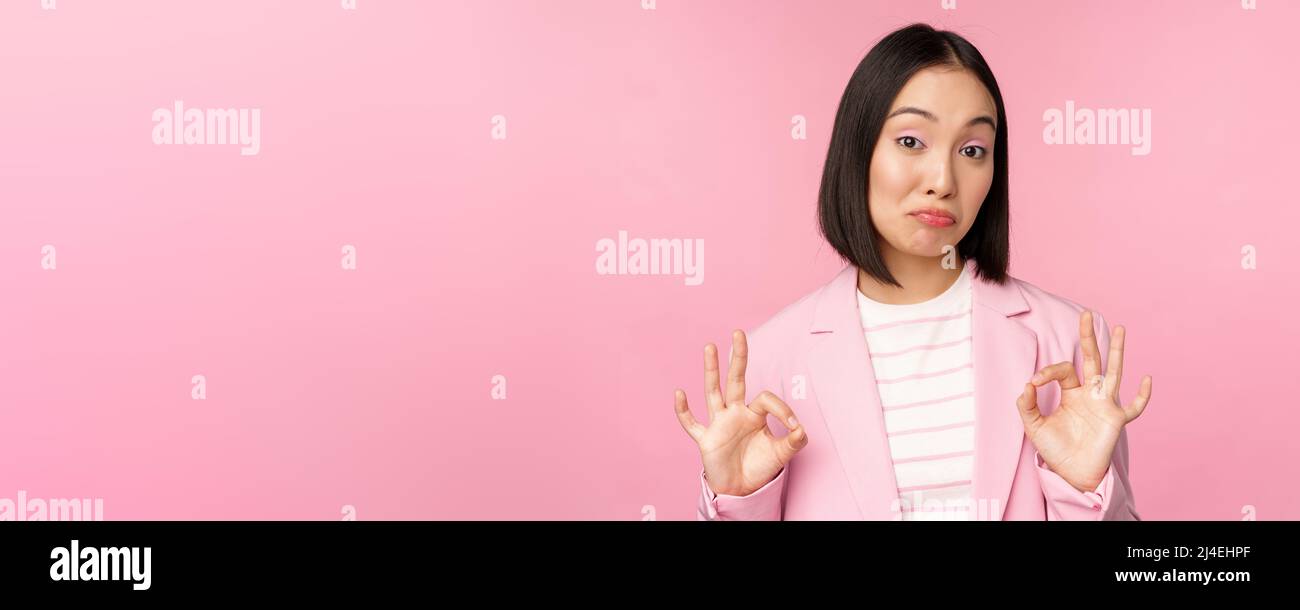 Not bad. Impressed businesswoman, asian office lady showing okay sign ...