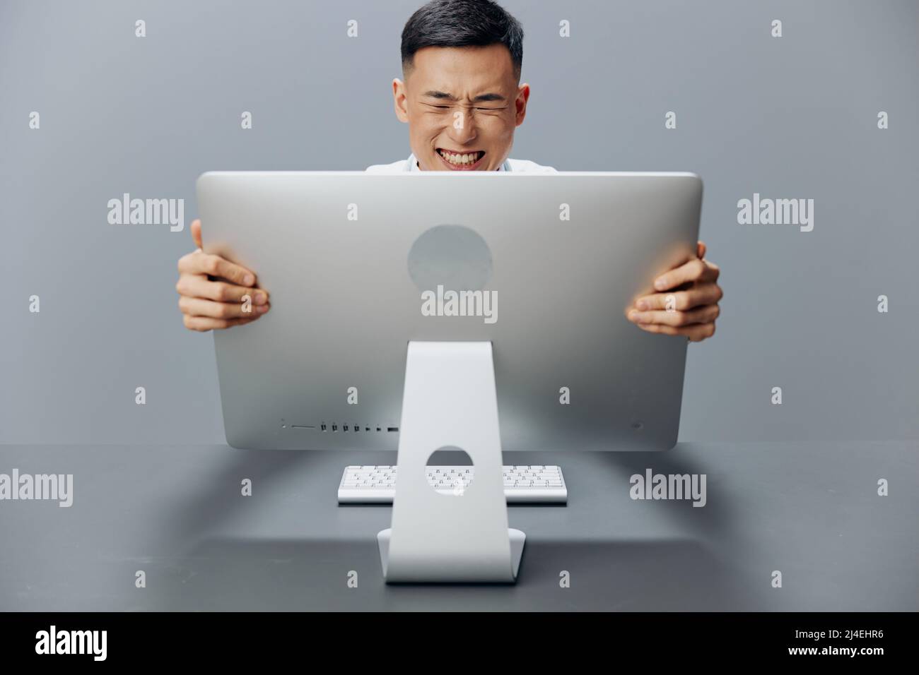 worker holding on to the monitor emotions office Gray background Stock ...