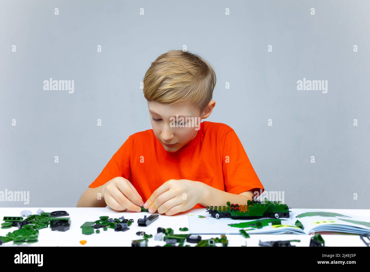 the boy plays with the plastic constructor connects the details Stock ...