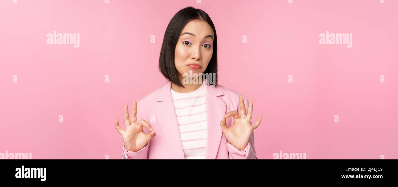 Not bad. Impressed businesswoman, asian office lady showing okay sign ...