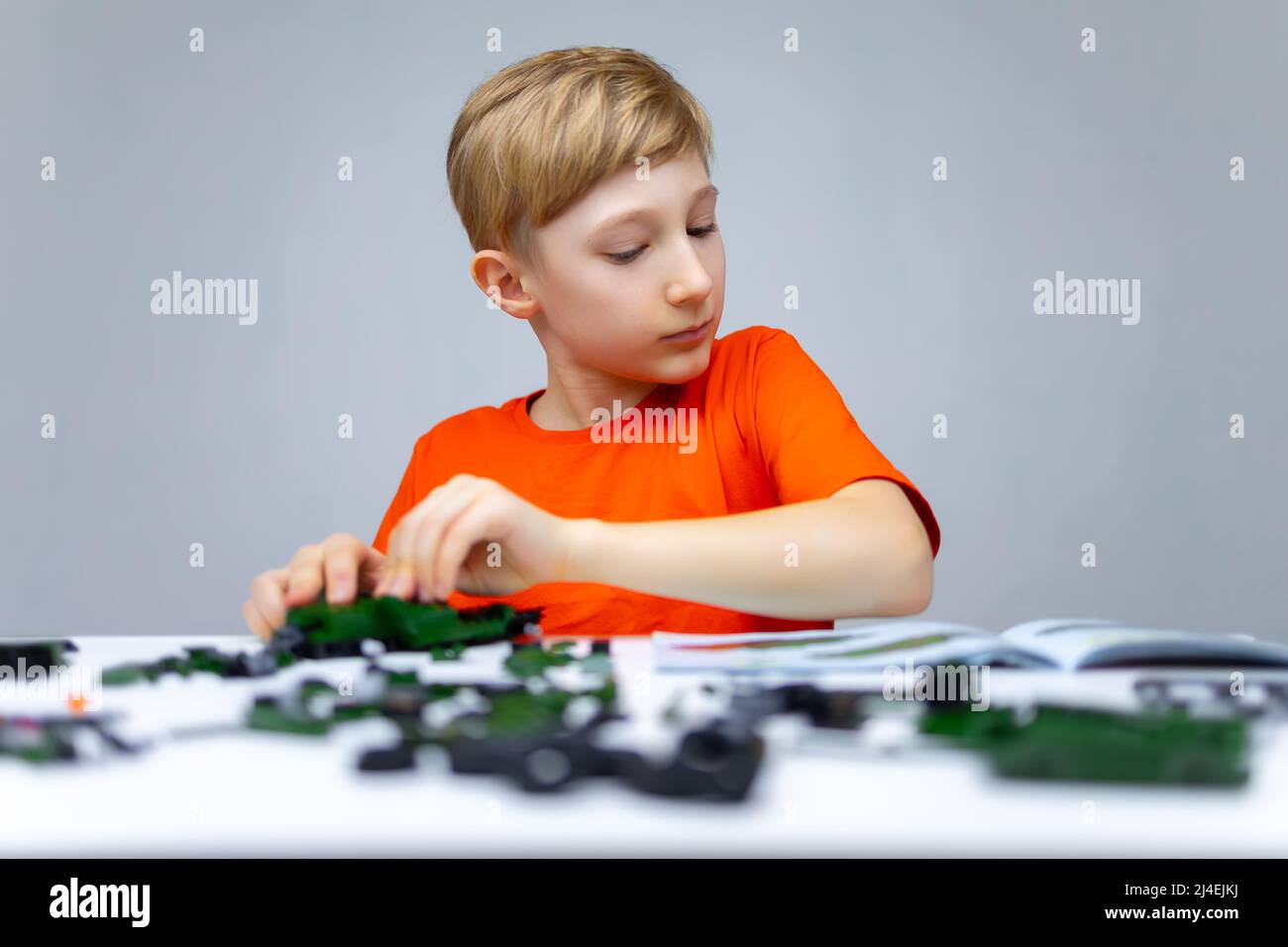 the boy is playing with a plastic constructor, he will make ...