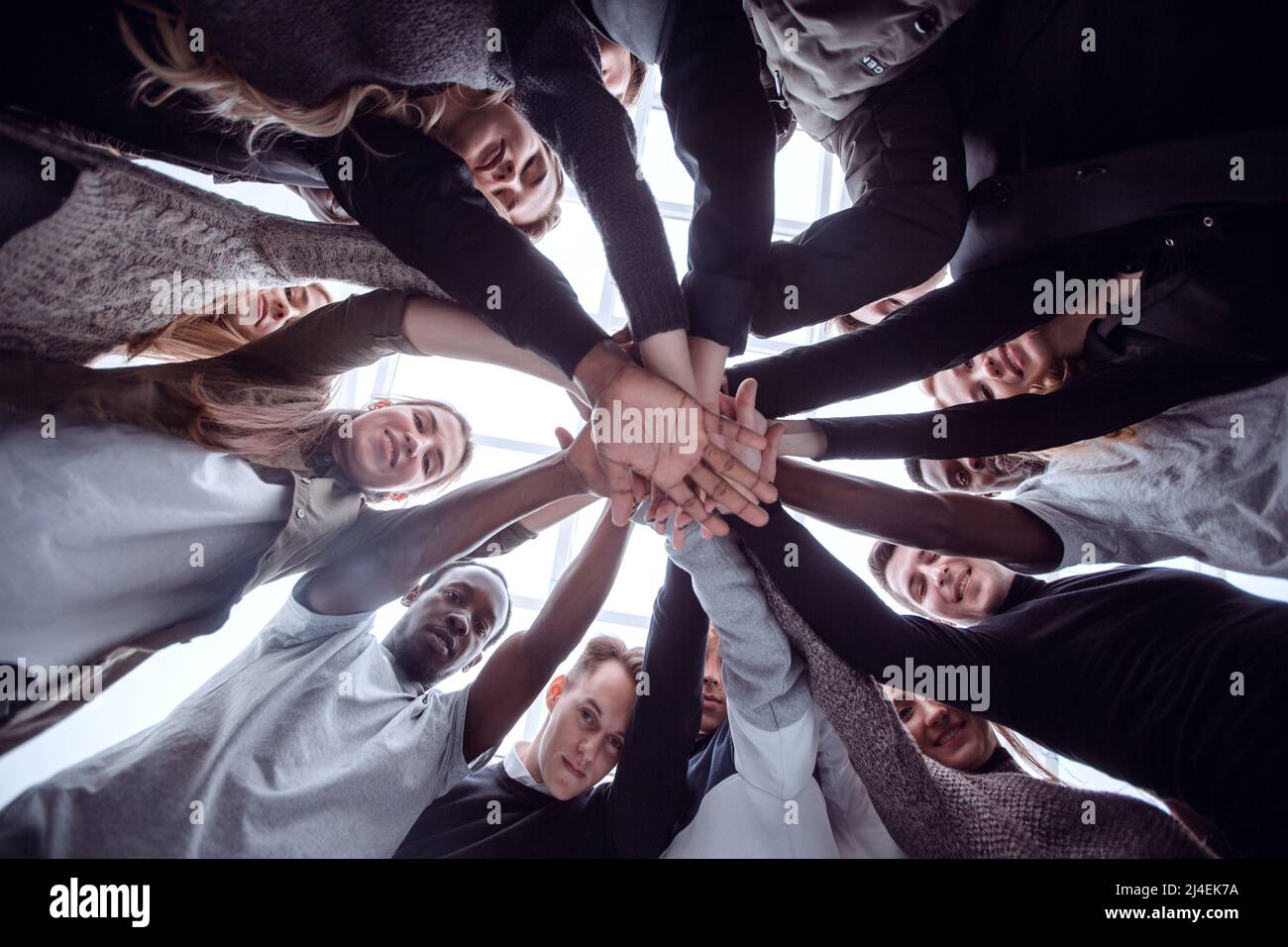 bottom view. group of happy young people making a tower out of their ...