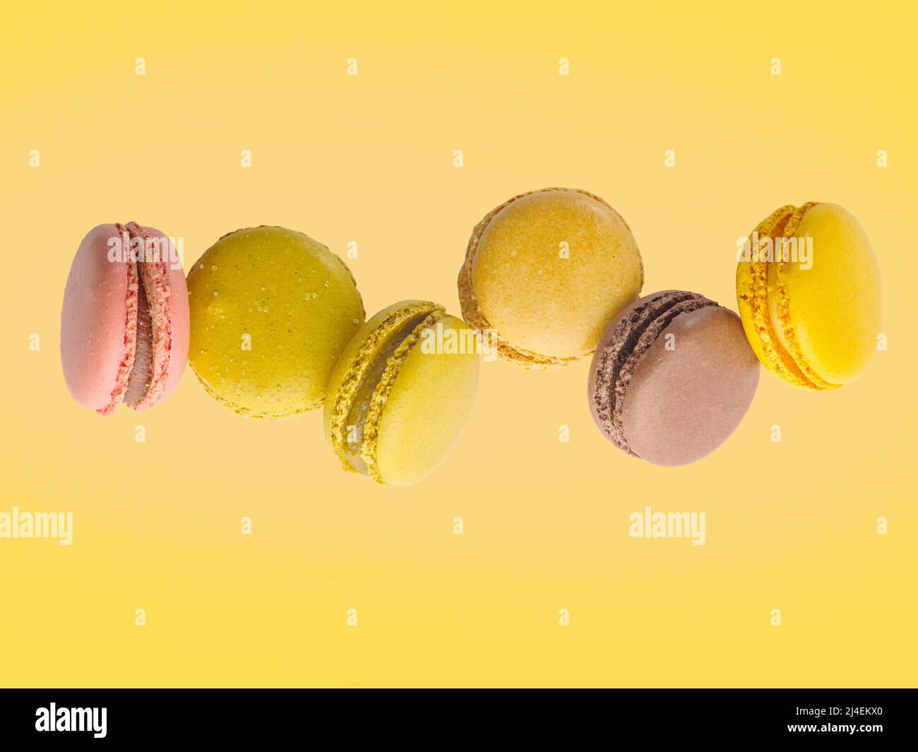 Appetizing French pastries - macaroons on a pale yellow background ...