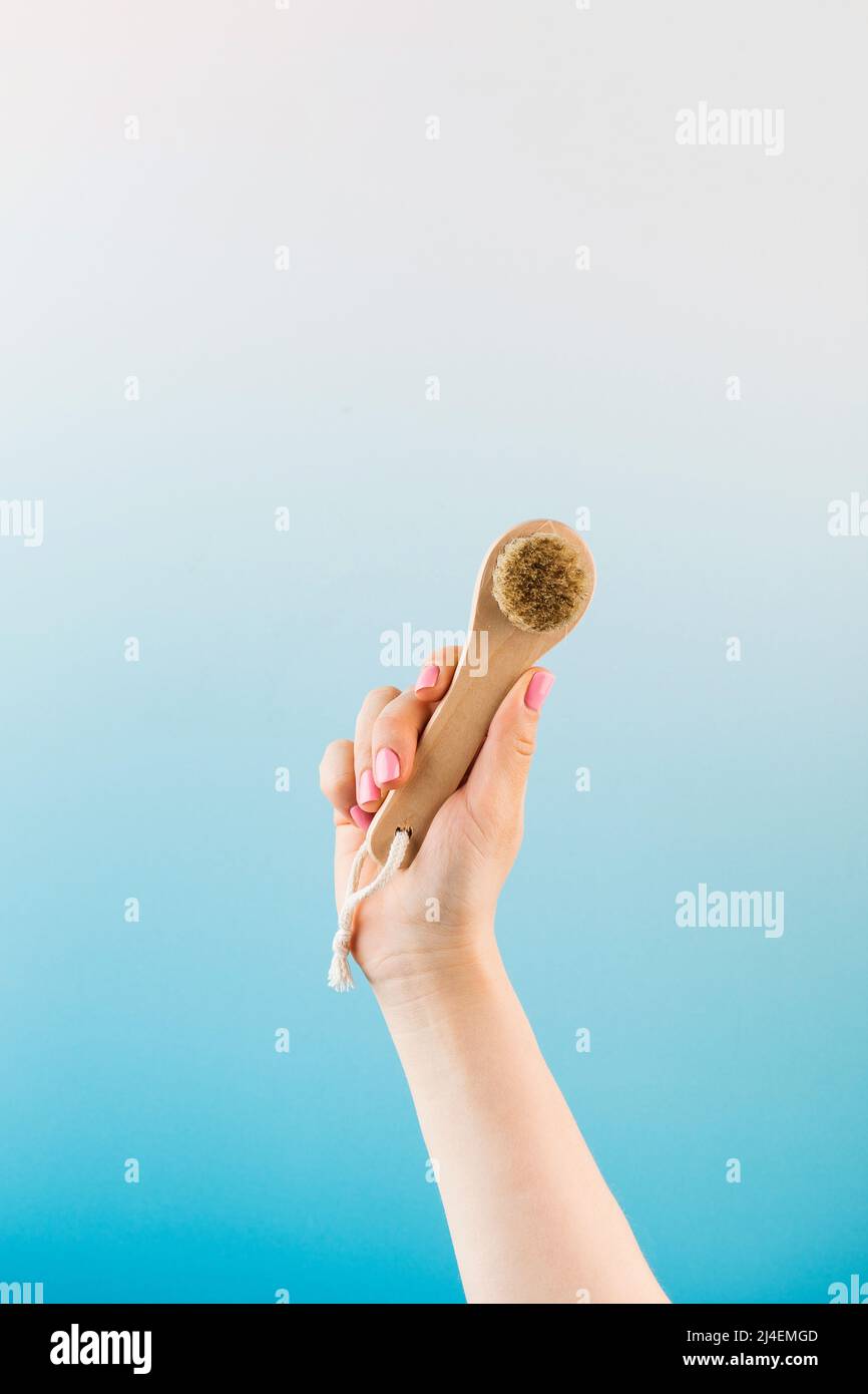 Exfoliating dry facial brush made of natural bristles in a woman's hand ...