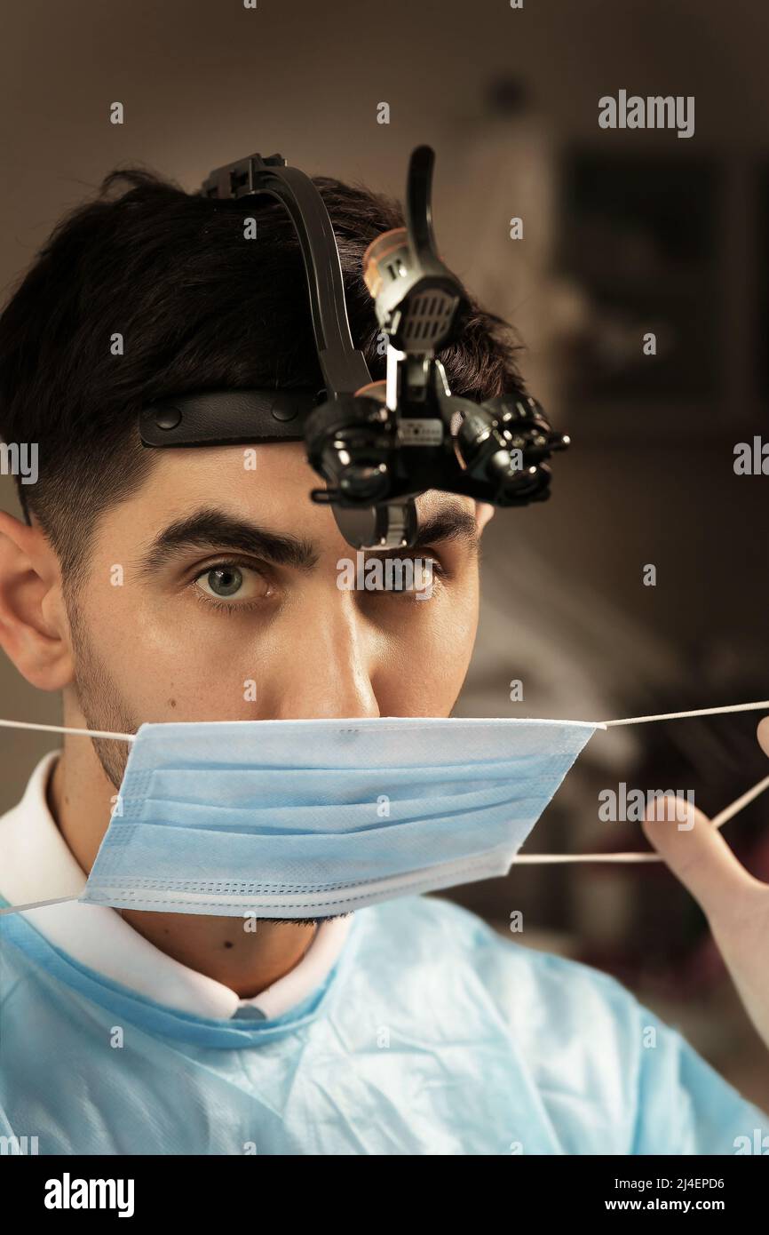Doctor putting a face mask standing on office background. Protection ...