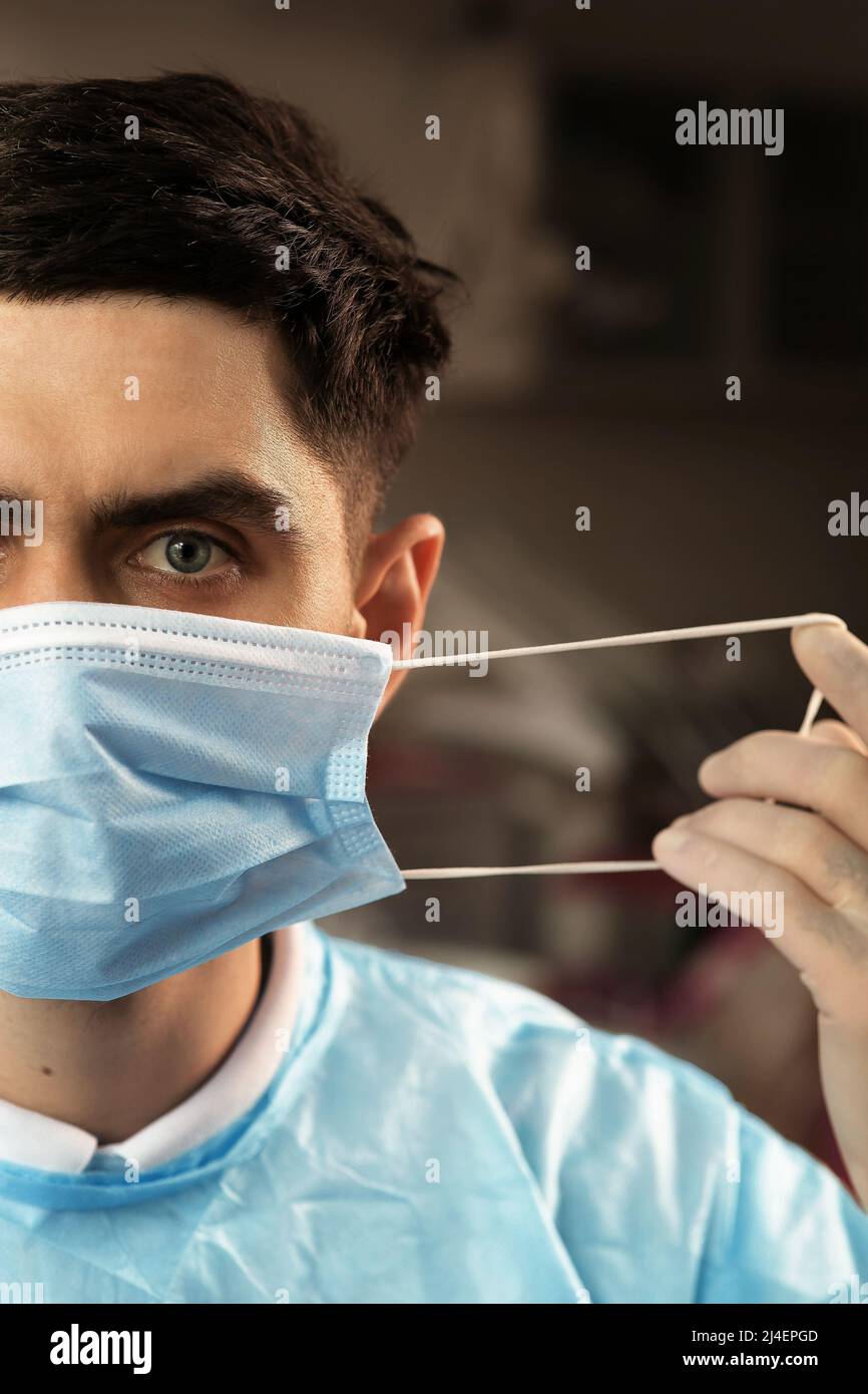 Doctor putting a face mask standing on office background. Protection ...
