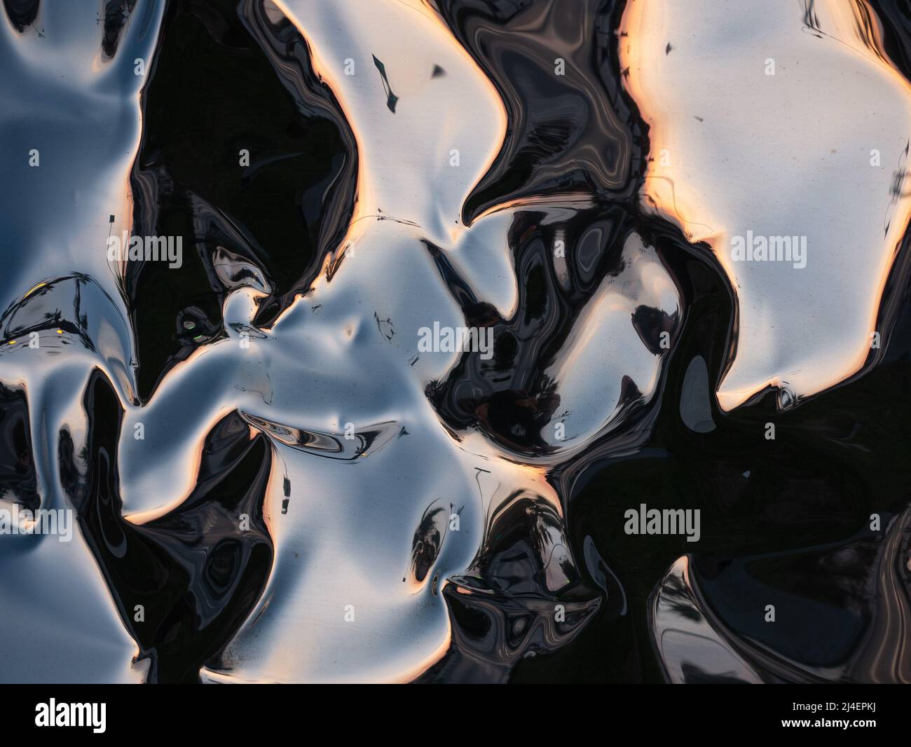 Curvy surface of mirror polished shiny metal reflecting lights and ...
