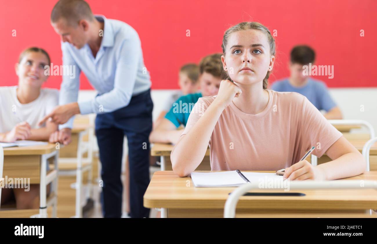 Teenage girl making notes of teacher lecture in college Stock Photo - Alamy