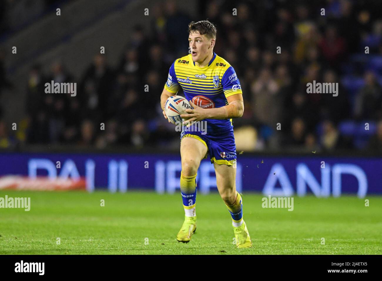 Josh Thewlis #22 of Warrington Wolves runs forward with the ball Stock ...