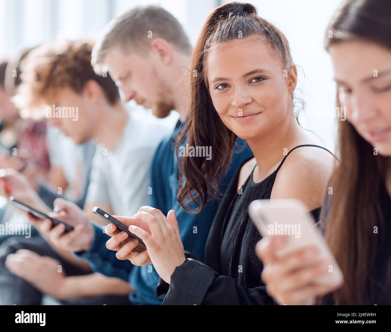 group of serious young people looking at their smartphone screens Stock ...