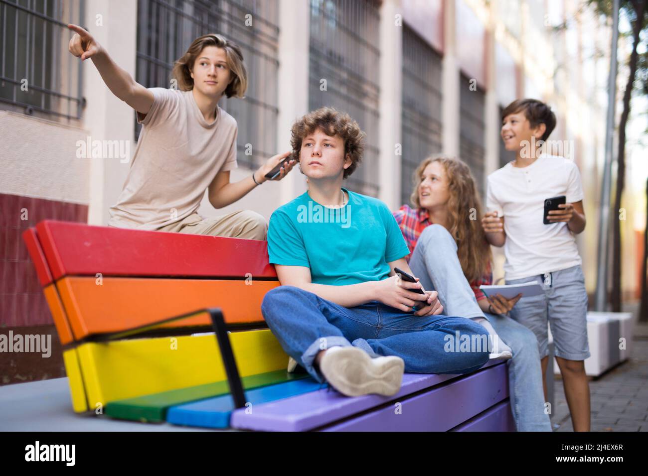 Schoolchildren sitting on bench in schoolyard Stock Photo - Alamy
