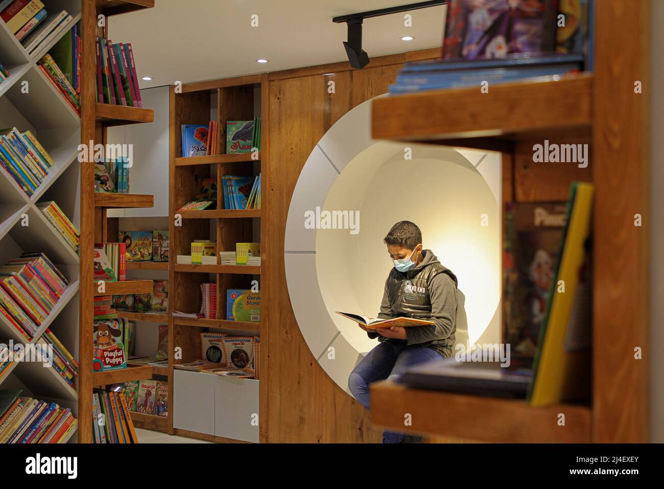 Gaza. 14th Apr, 2022. A boy reads a book at Samir Mansour's library in ...