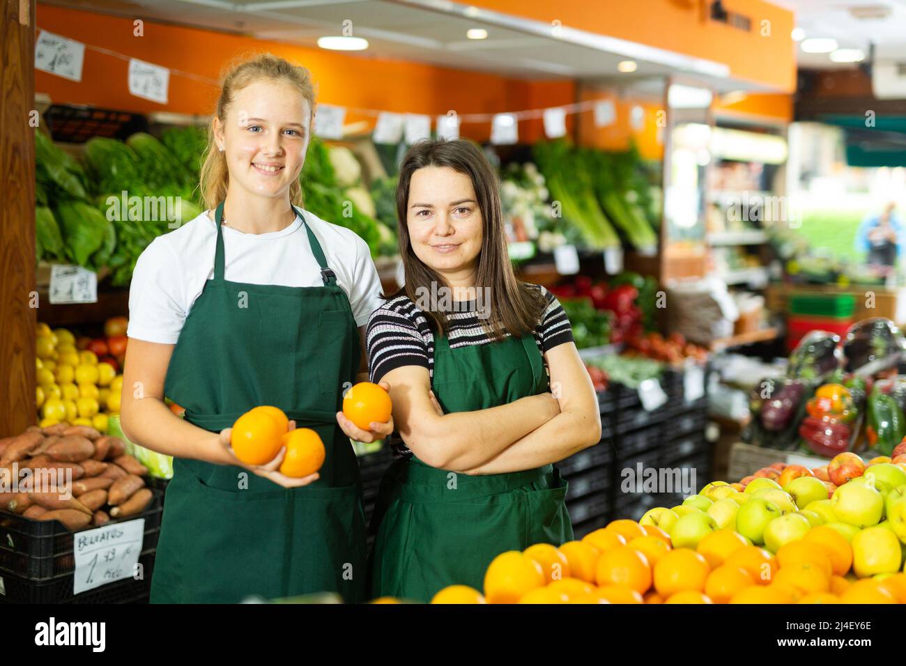 Portrait of a confident saleswoman with a fifteen-year-old trainee girl ...