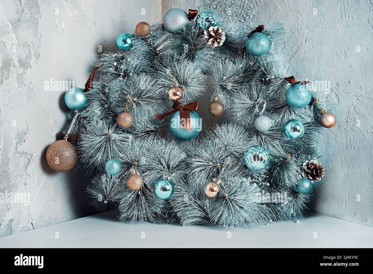 Christmas light blue wreath on a concrete wall background Stock Photo ...