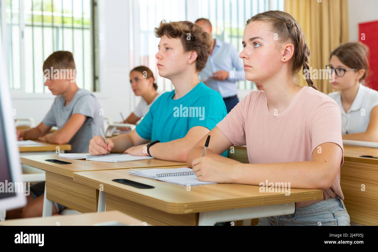 Teenage girl making notes of teacher lecture in college Stock Photo - Alamy