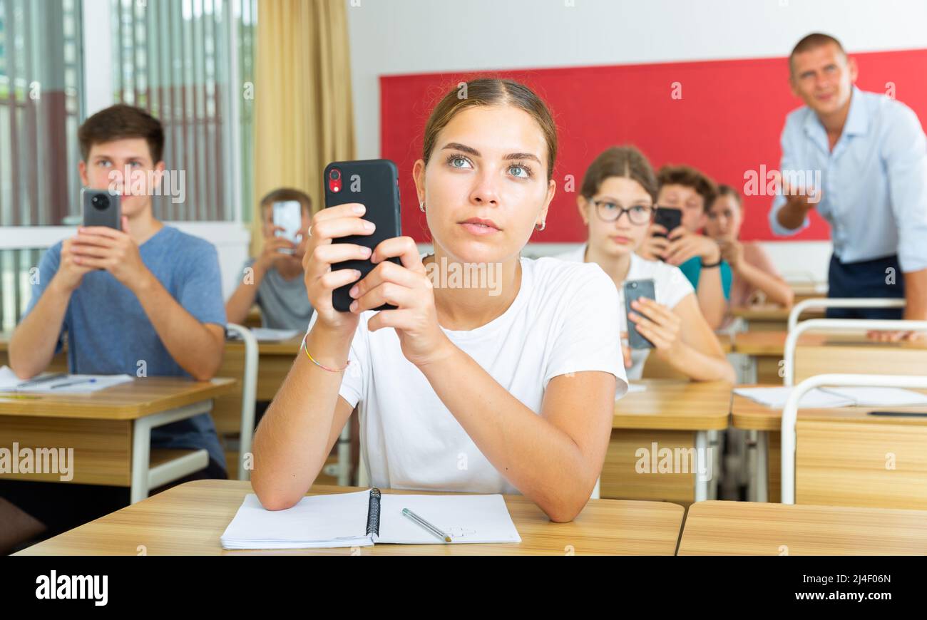 Girl high school student using mobile phone on lecture in class Stock ...