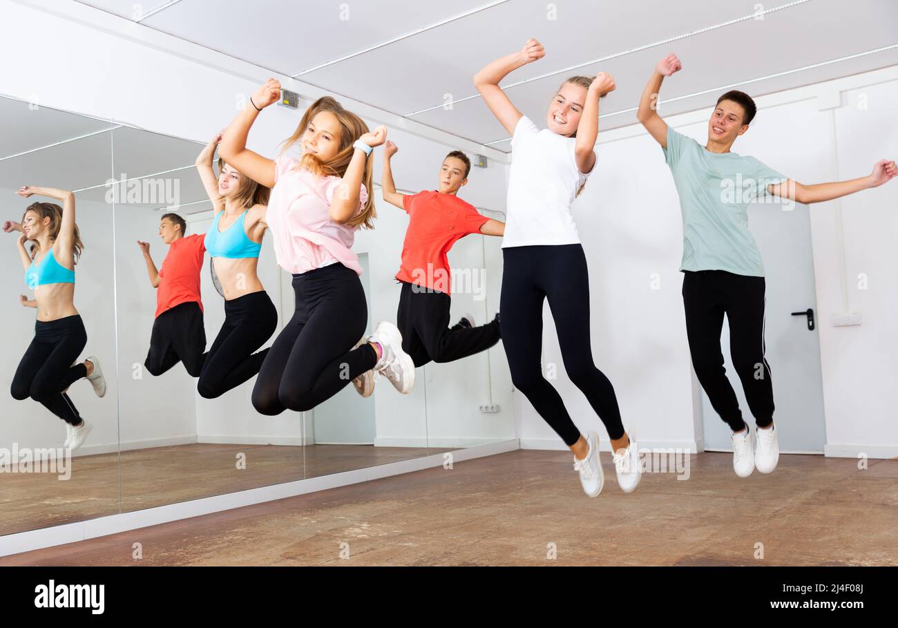 Teenagers with teacher jumping in dance hall Stock Photo - Alamy