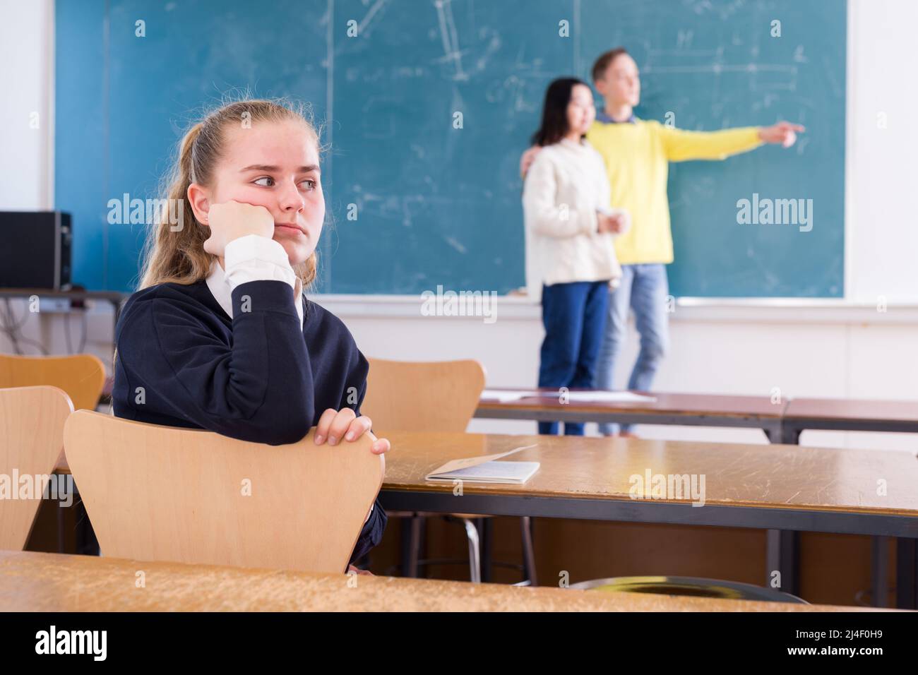 Unhappy girl sitting in class Stock Photo - Alamy