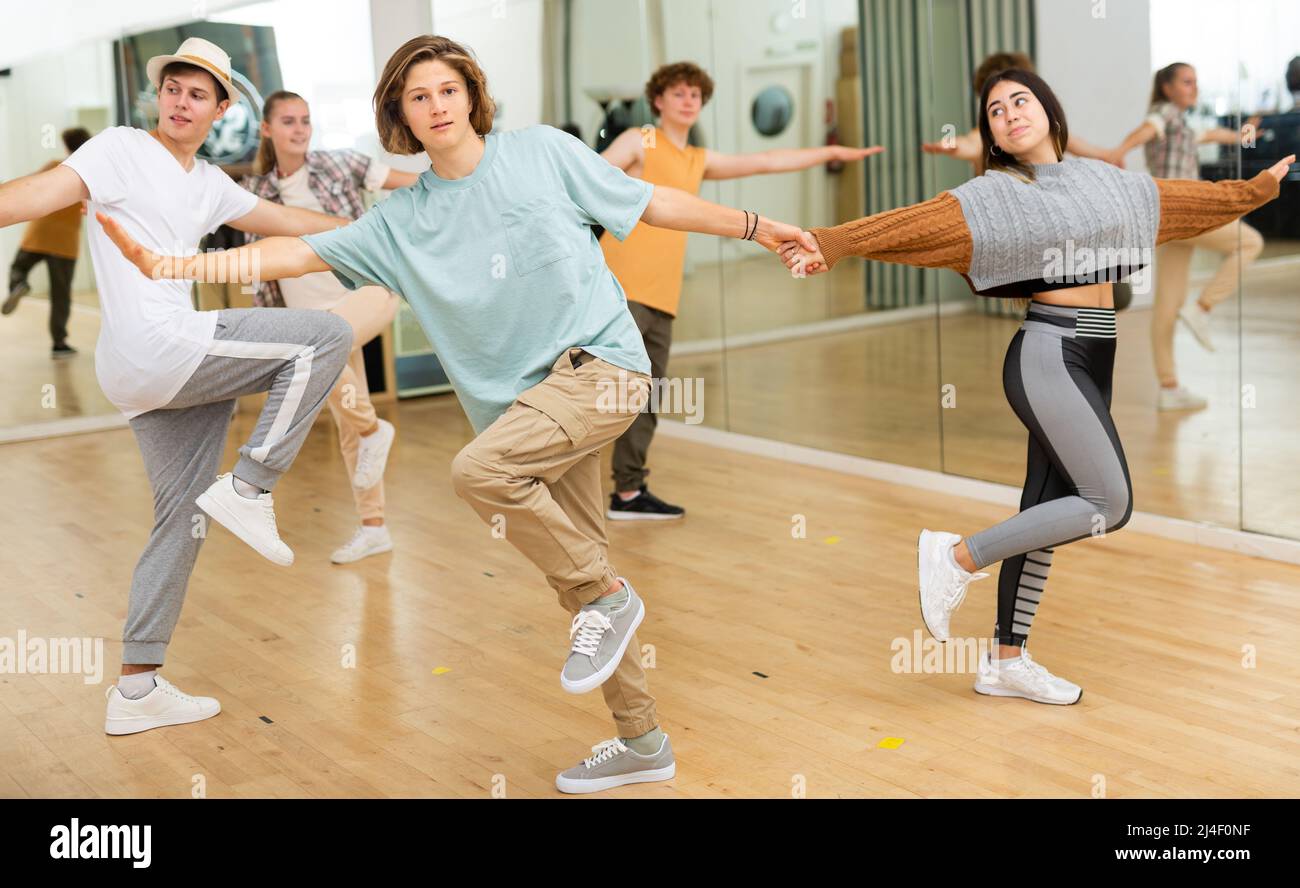 Teenagers practicing dynamic boogie-woogie in pairs in dance studio for ...