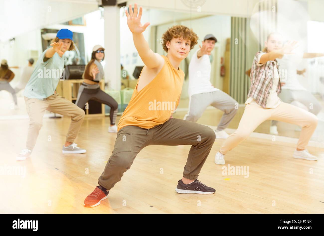Teen b-boy dancing with group of friends in dance studio Stock Photo ...