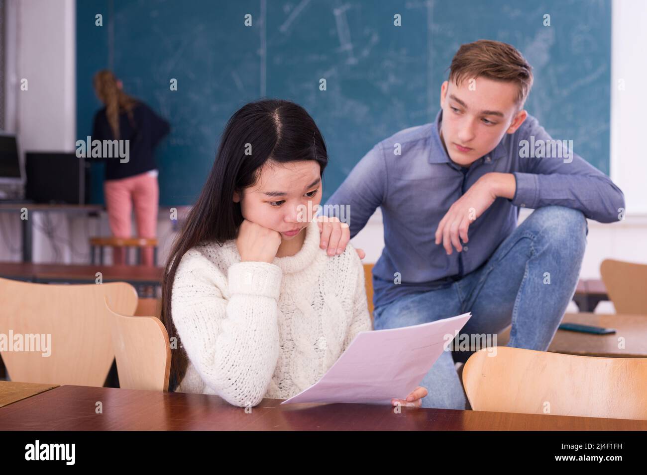 Classmate comforting upset asian girl student Stock Photo - Alamy