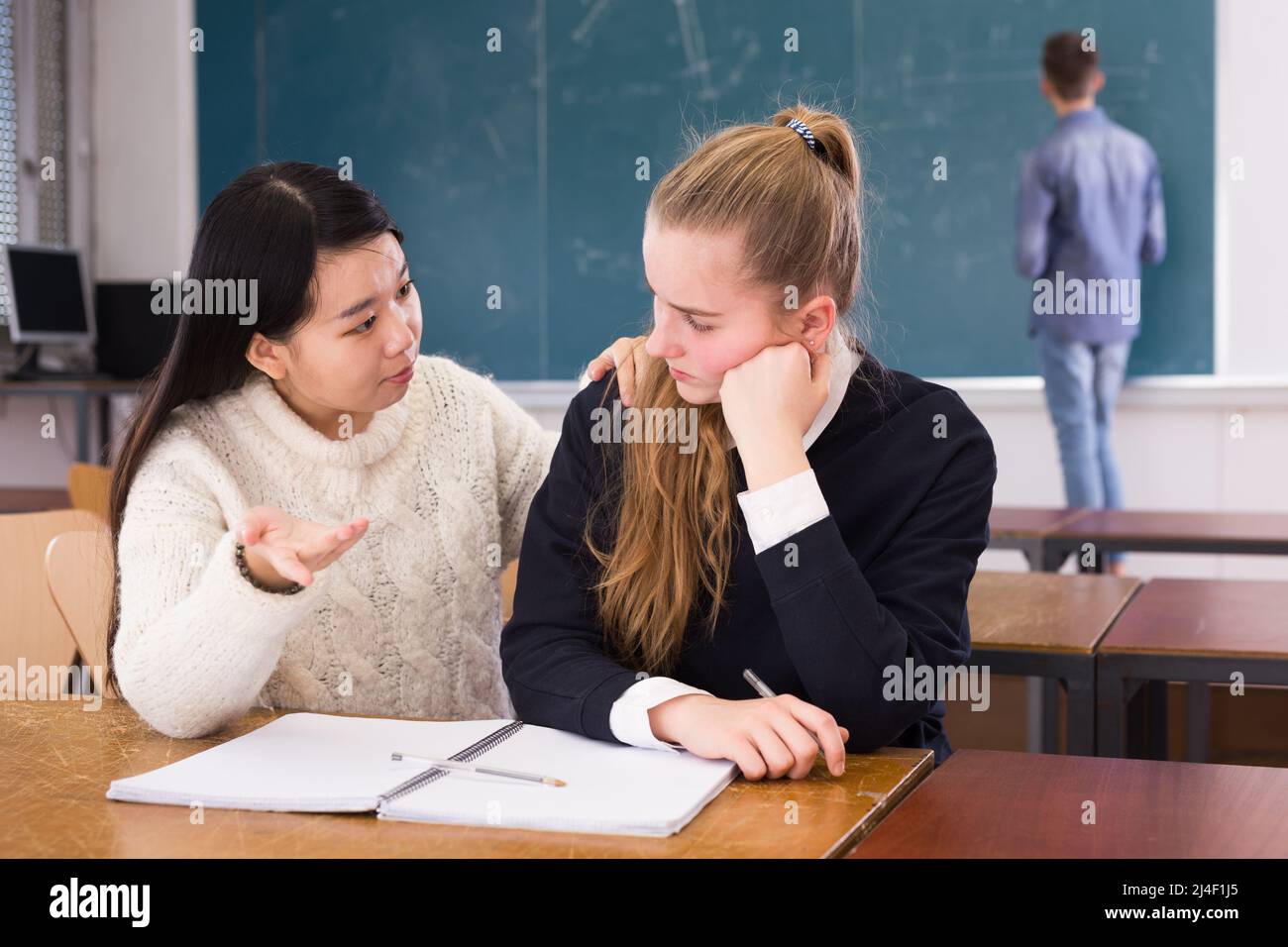 Tired female students during writing notes in classroom Stock Photo - Alamy