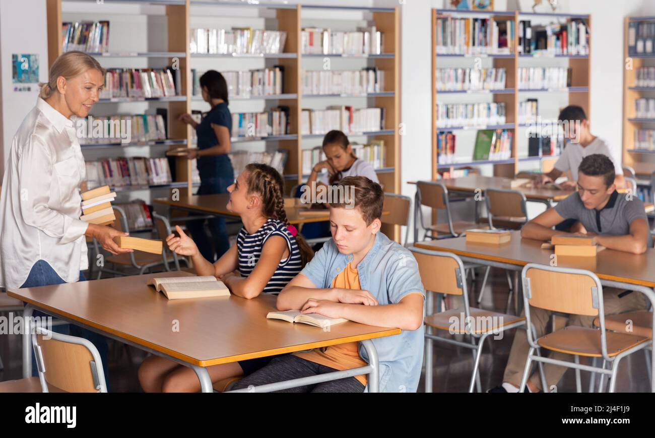 Boy preparing for lesson in school library, reading textbooks Stock ...