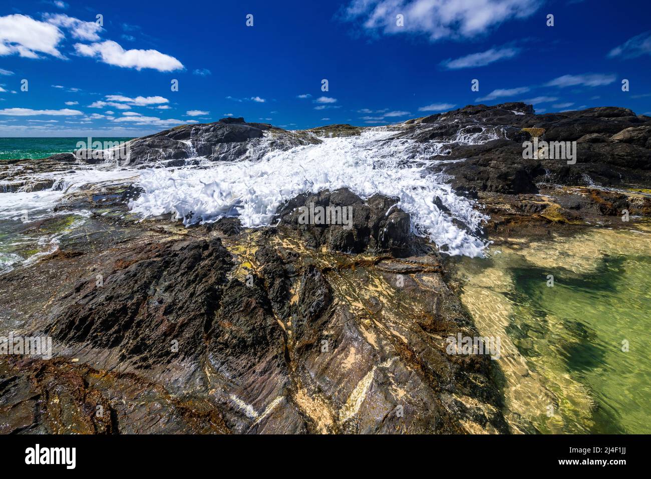 Water cascades over the rocks and the famous Champagne Pools on Fraser ...