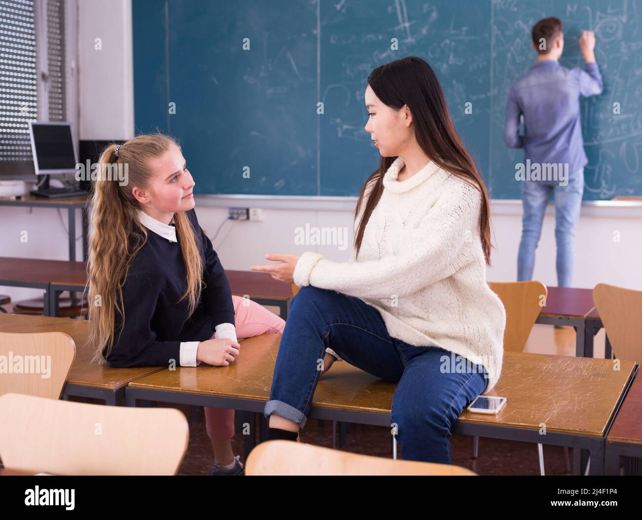 Student girls communicating in classroom Stock Photo - Alamy